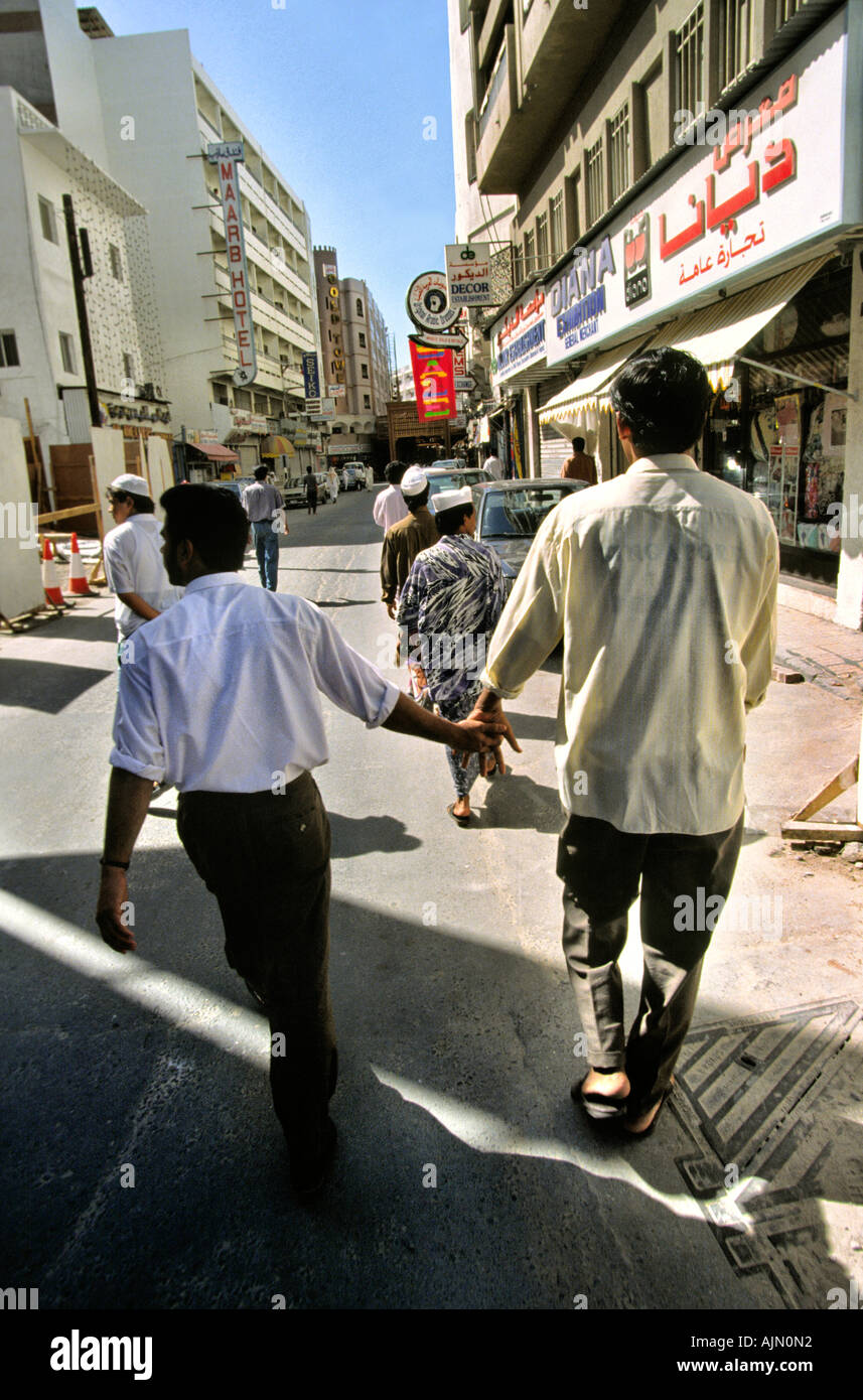 UAE Dubai pakistani migrant men holding hands walking down street Stock ...