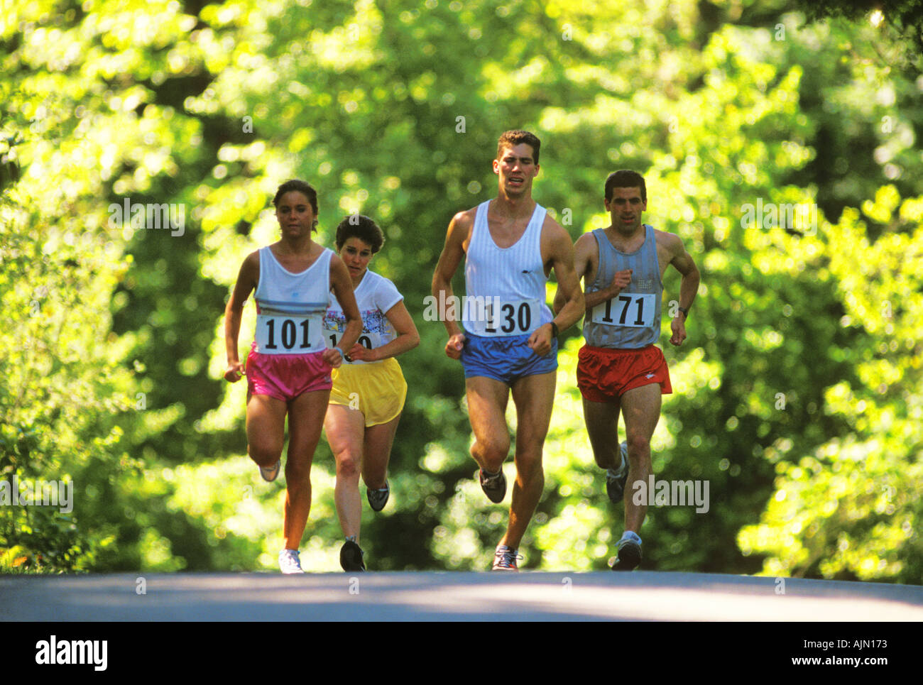 Four runners in a road race show varying levels of distress and effort ...