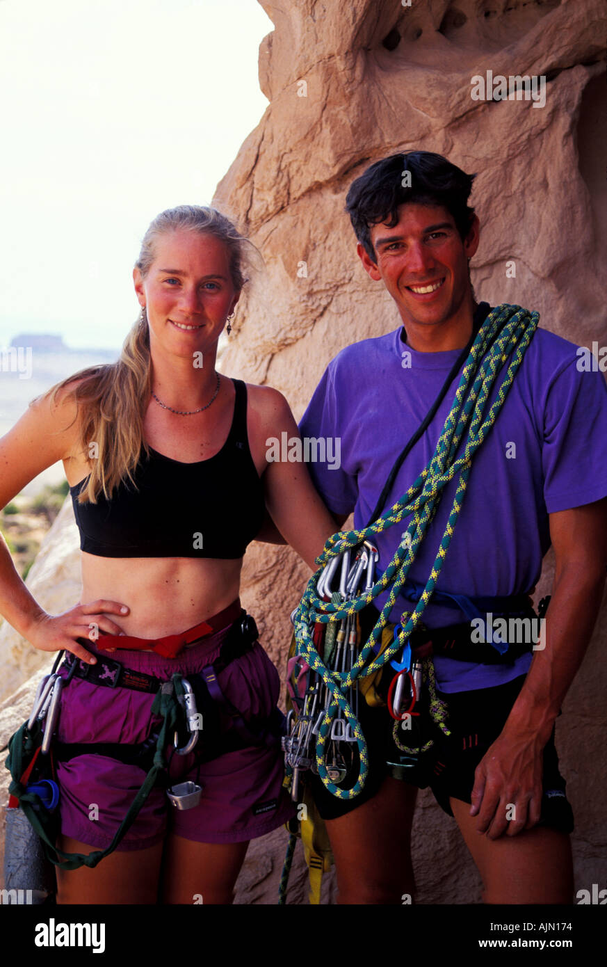 A rock climbing couple pose for a portrait during a climb in Utah Stock ...
