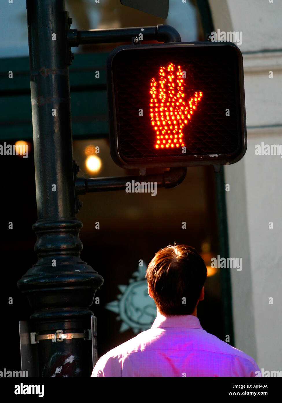 MAN CROSSING ROAD AGAINST DON'T WALK SIGN Stock Photo - Alamy