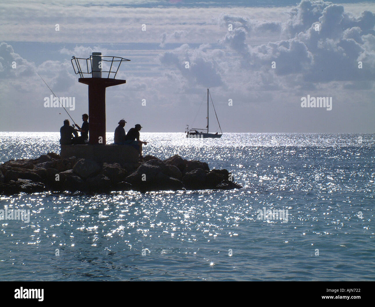 Group of people silhouetted on a jetty in Majorca Stock Photo - Alamy