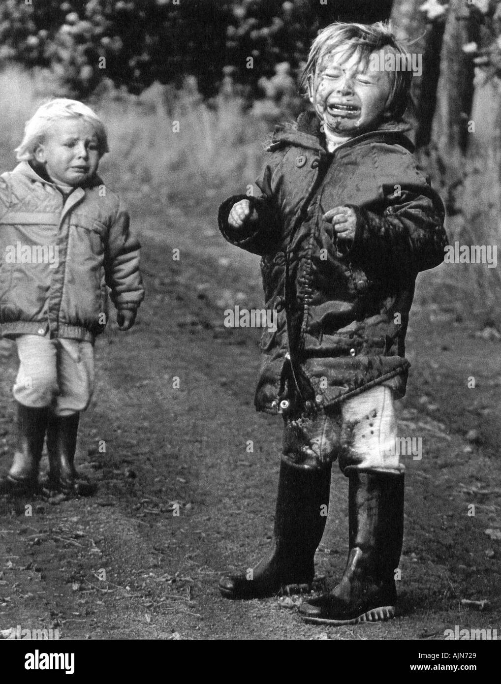Young child crying after falling into dirty puddle Stock Photo - Alamy