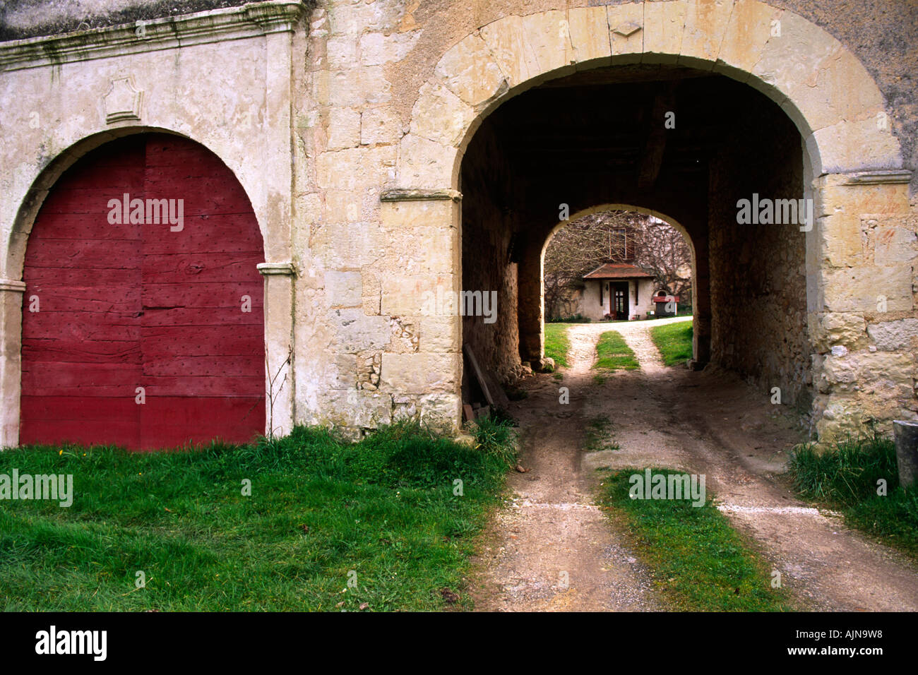Arched entrance to a farm courtyard. Perigord region of France. La ...