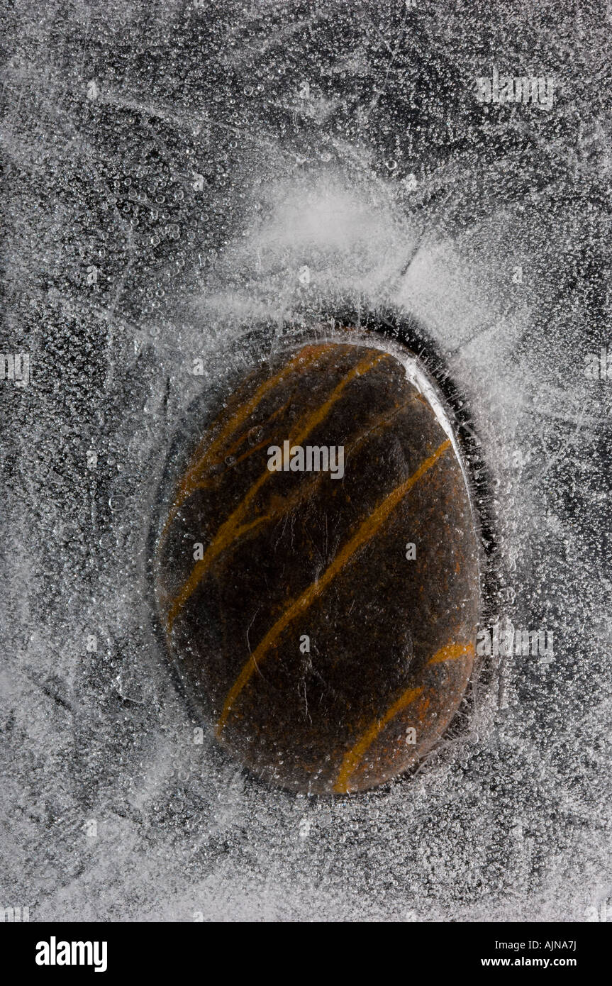 Pebble encased in ice Stock Photo - Alamy