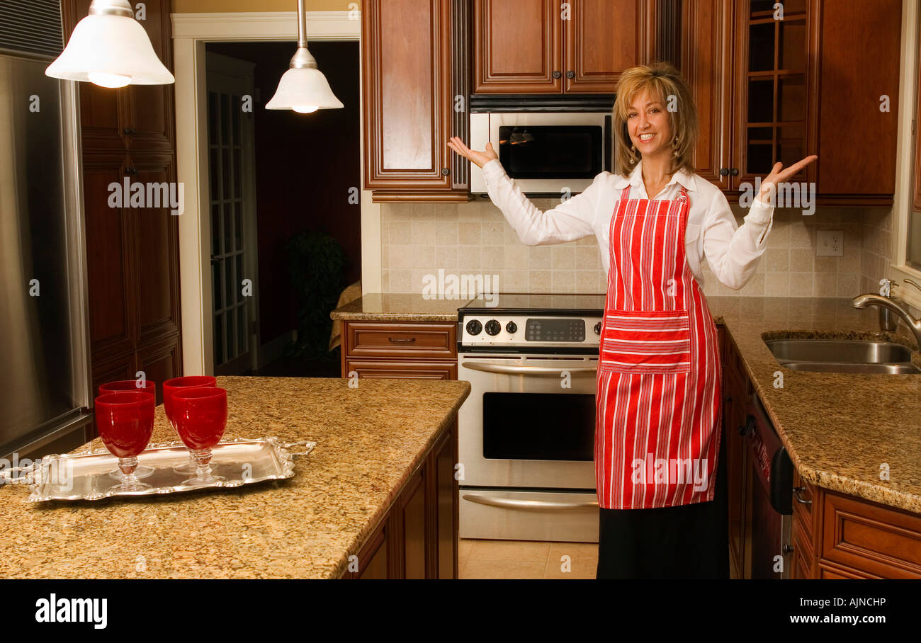 Woman in kitchen wearing apron Stock Photo - Alamy