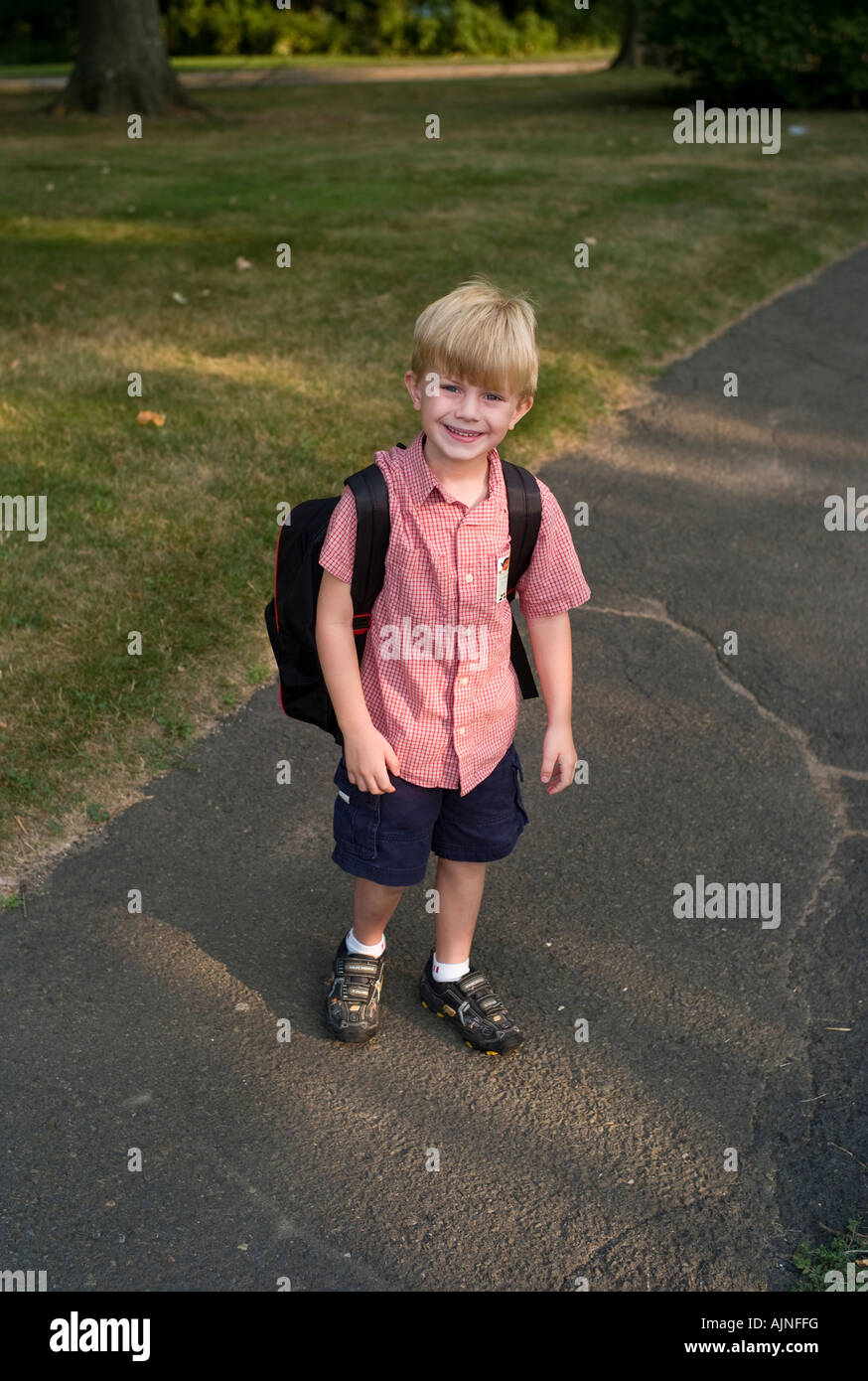 Small child with backpack smiling Stock Photo - Alamy