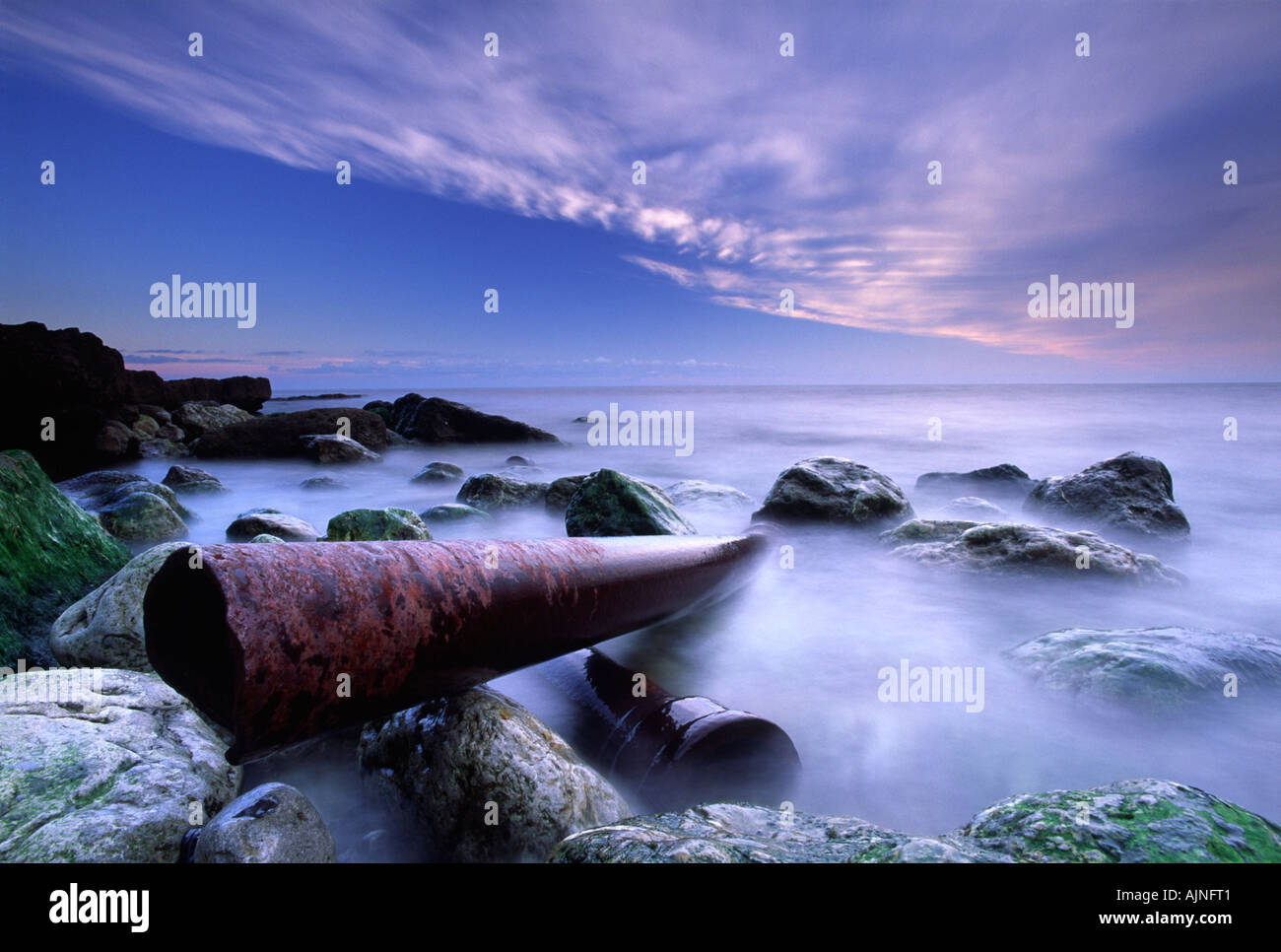 Environmental theme of rusty pipes leading into the sea at Bran Ledge ...