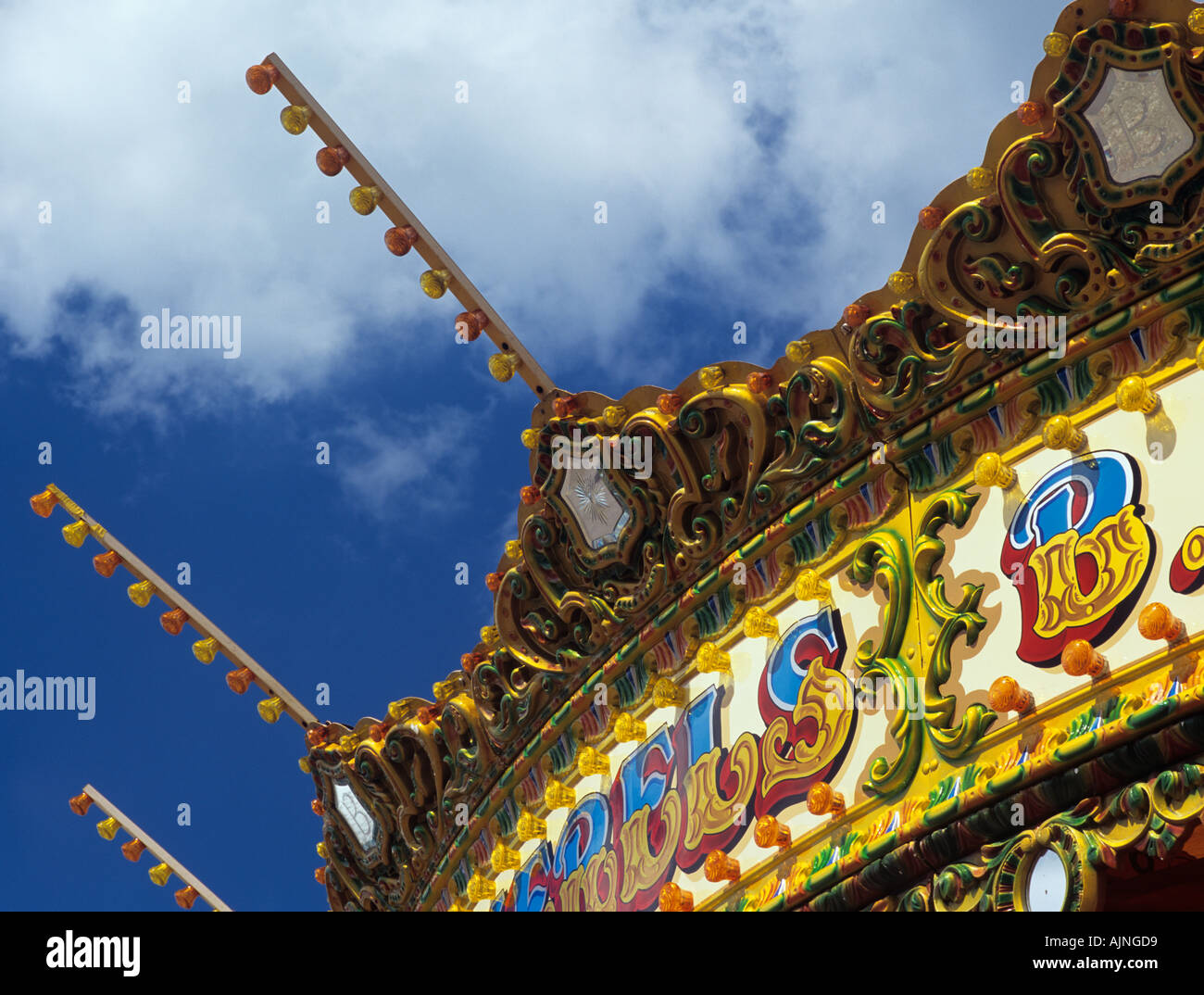 COLOURFUL FAIRGROUND CAROUSEL detail against blue sky England UK Stock ...