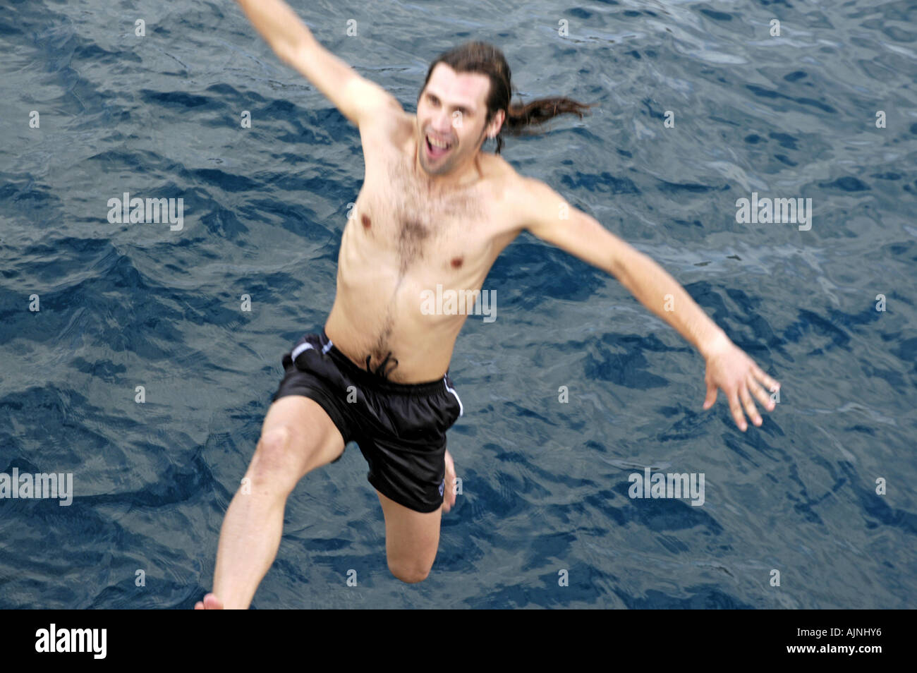 young man jumping off a boat Stock Photo - Alamy