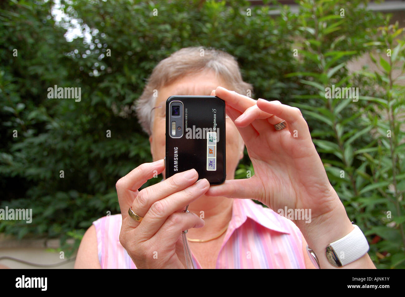 Mature lady using a digital camera Stock Photo - Alamy