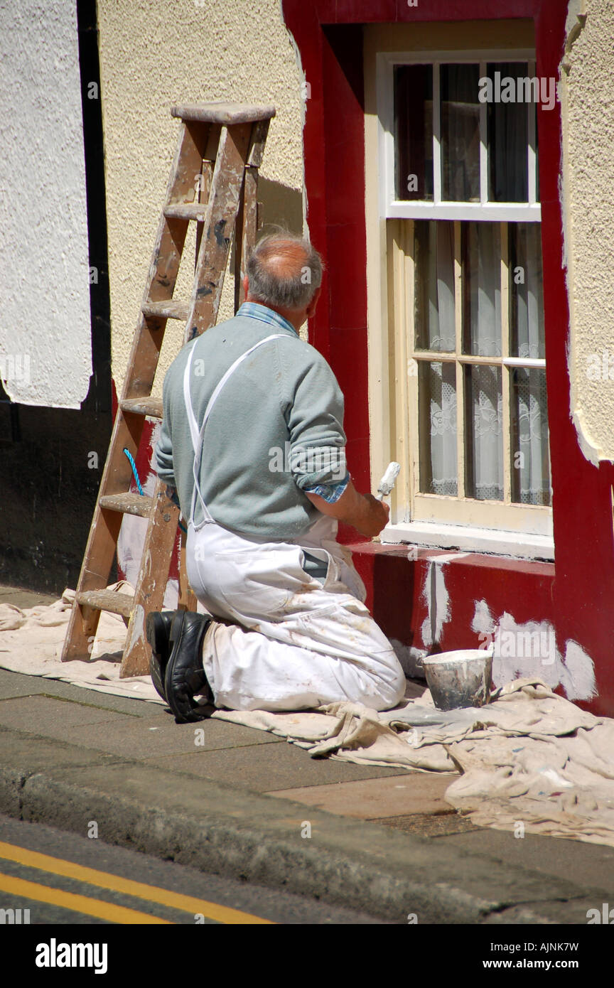 Painter and decorator painting a building in the street, UK Stock Photo ...
