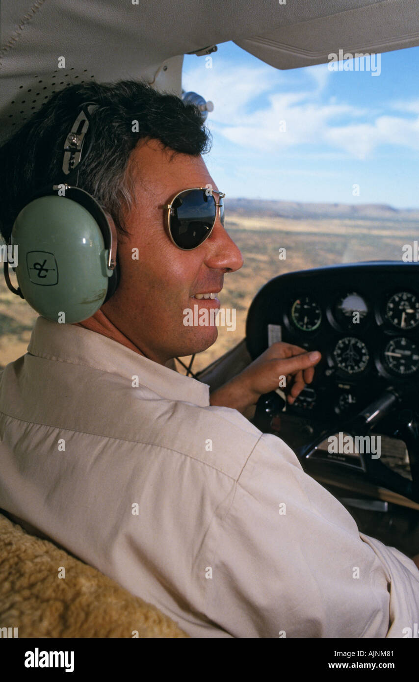 Ranch owner at controls of small plane used to cover his large cattle ...