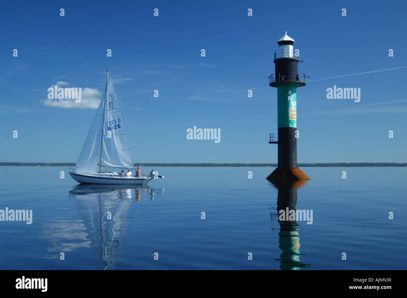 A Swedish yacht Folkboat class sailing past a light house in Kalmar ...