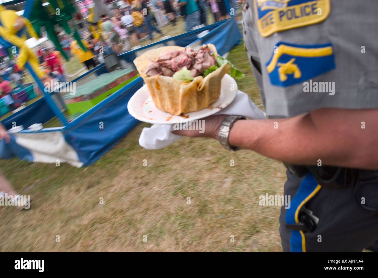 State police officer at a fair carrying a beef dinner Stock Photo - Alamy
