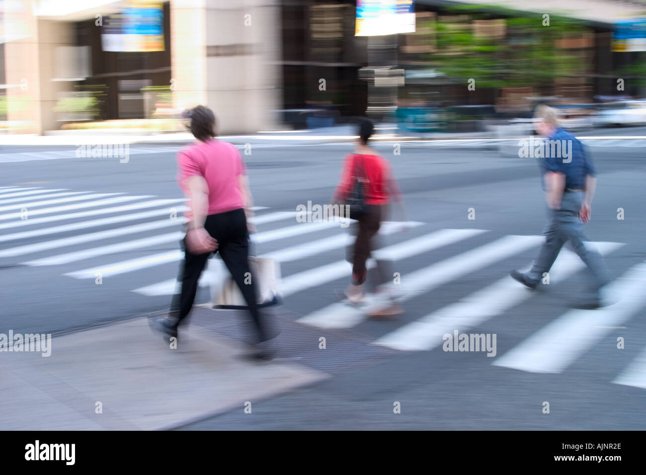People in a downtown city crosswalk walking across the street Stock ...