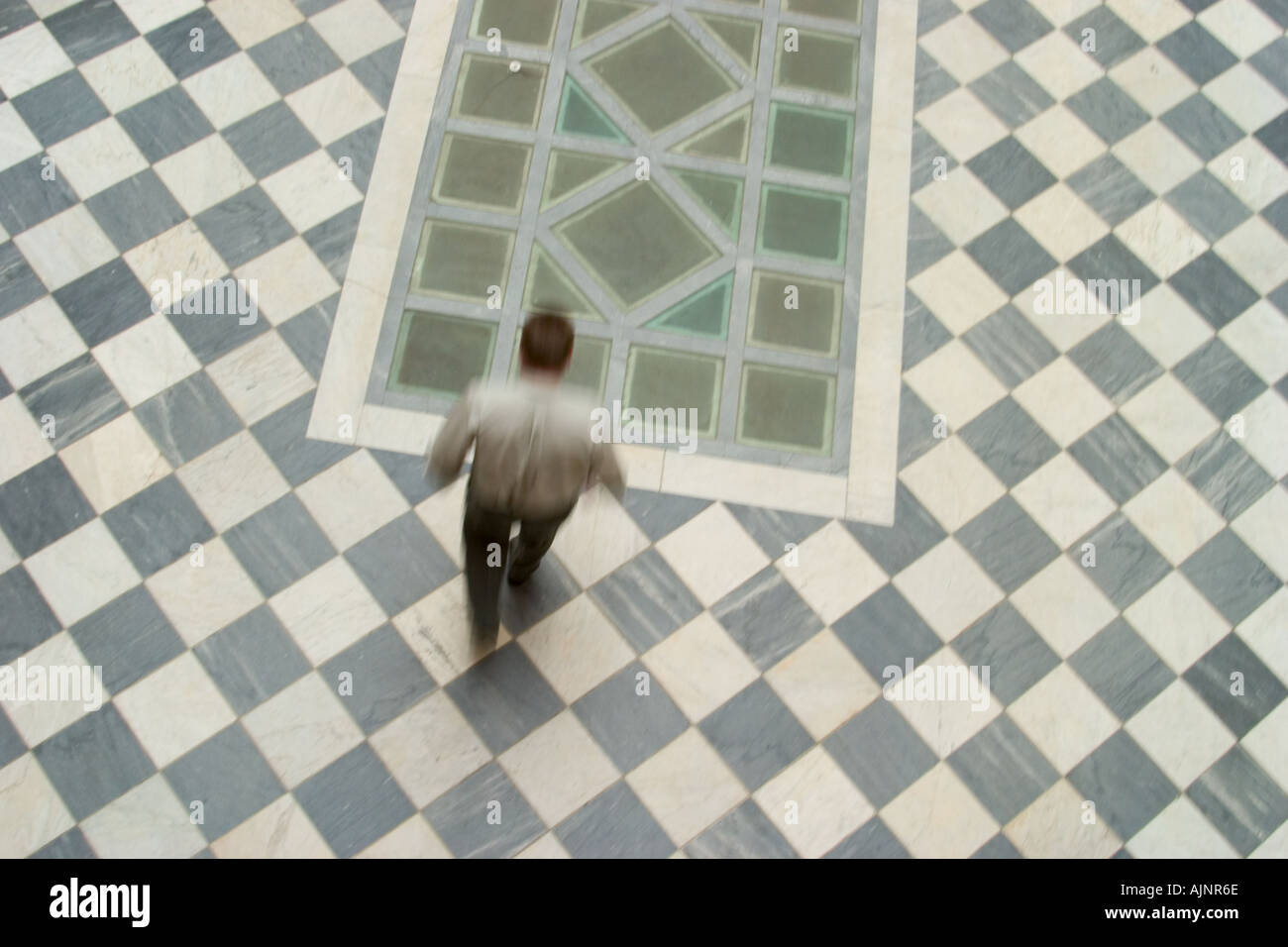 Men walking on a tile floor in the hallway of an office building Stock ...
