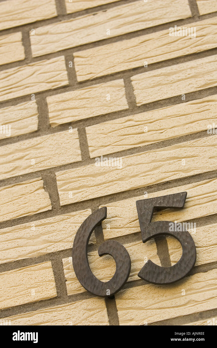 Number 65 mounted on a brick wall Stock Photo - Alamy