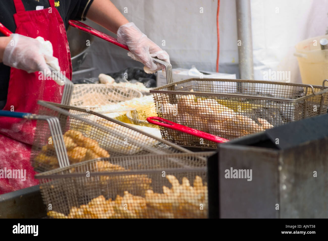 Restaurant worker preparing fried food at an outdoor festival Stock ...