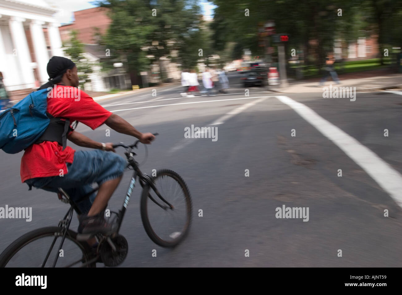Young black man riding a bicycle on a city street Stock Photo - Alamy