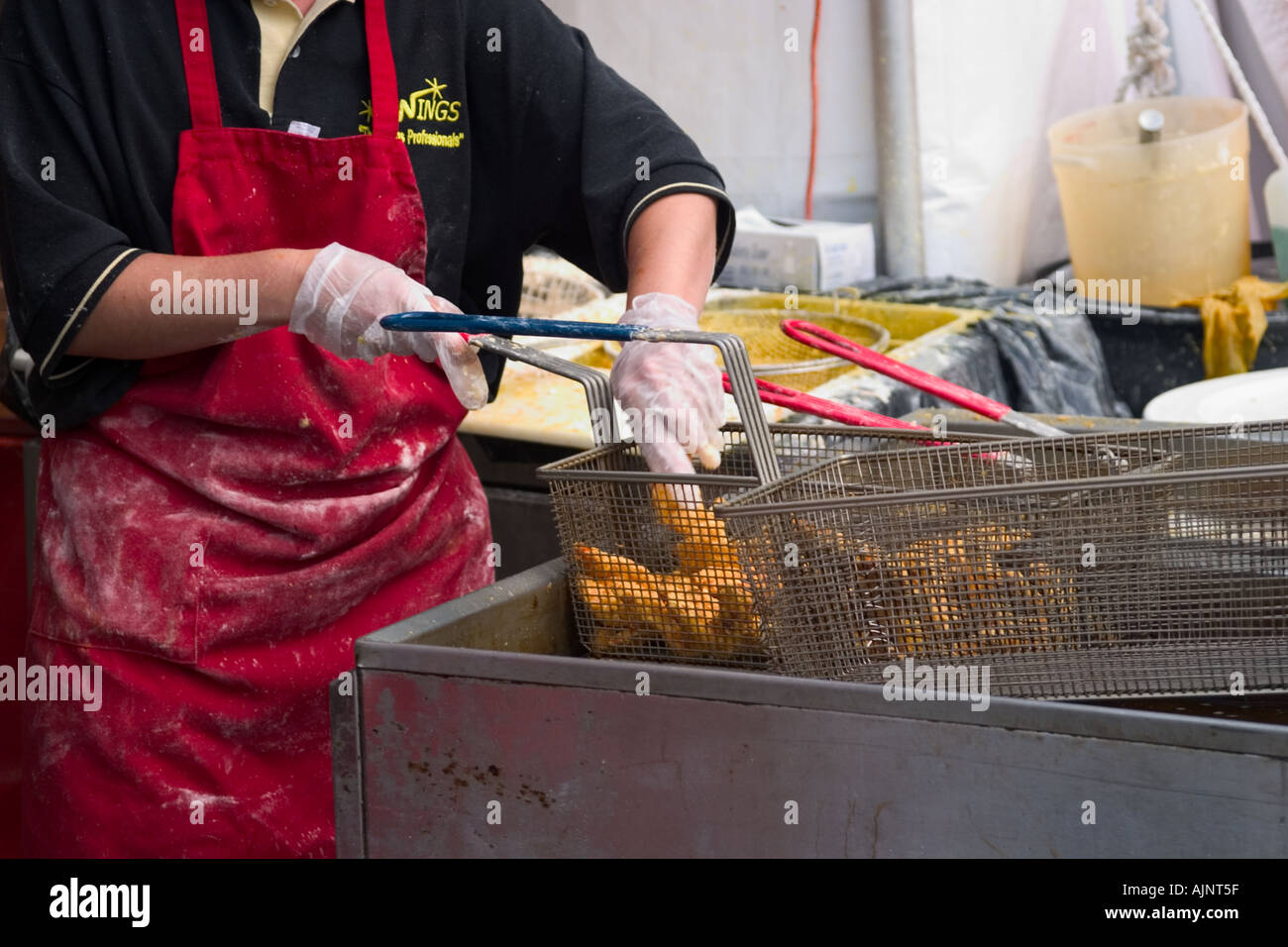 Restaurant worker preparing fried food at an outdoor festival Stock ...