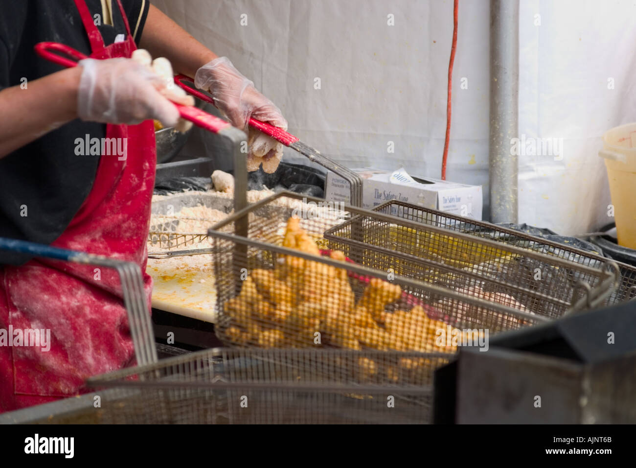 Restaurant worker preparing fried food at an outdoor festival Stock ...