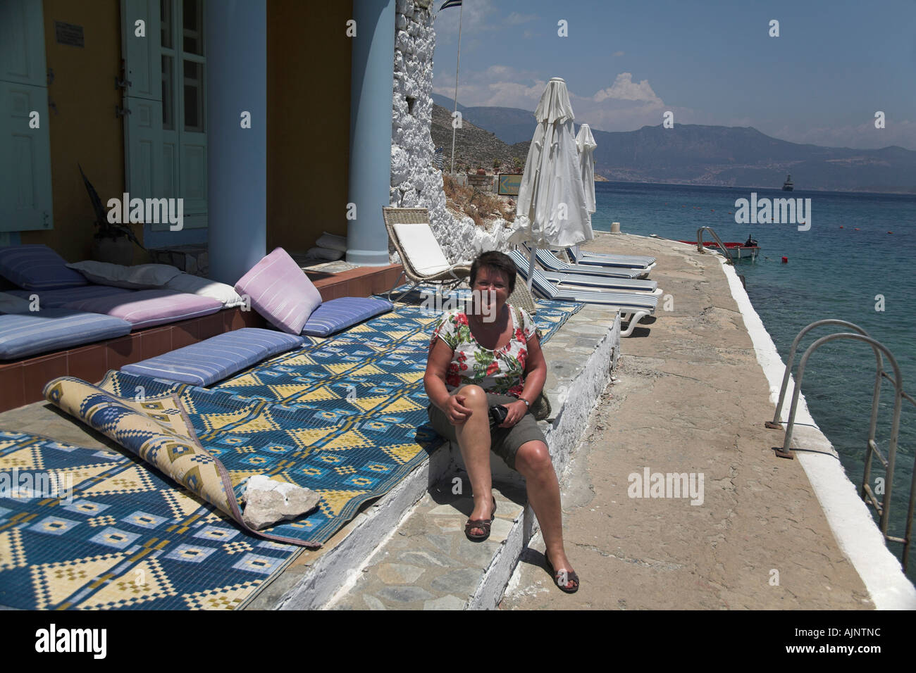 Stock photograph of woman relaxing on terrace Meis Greek Island Aegean ...
