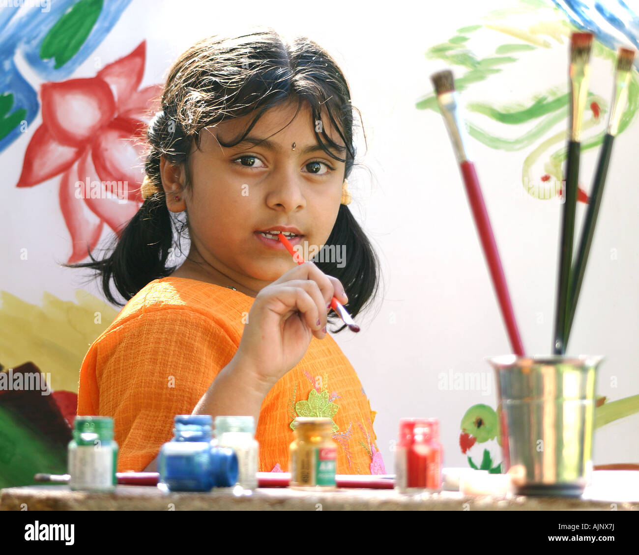 Portrait of a young girl with a painting brush Stock Photo - Alamy