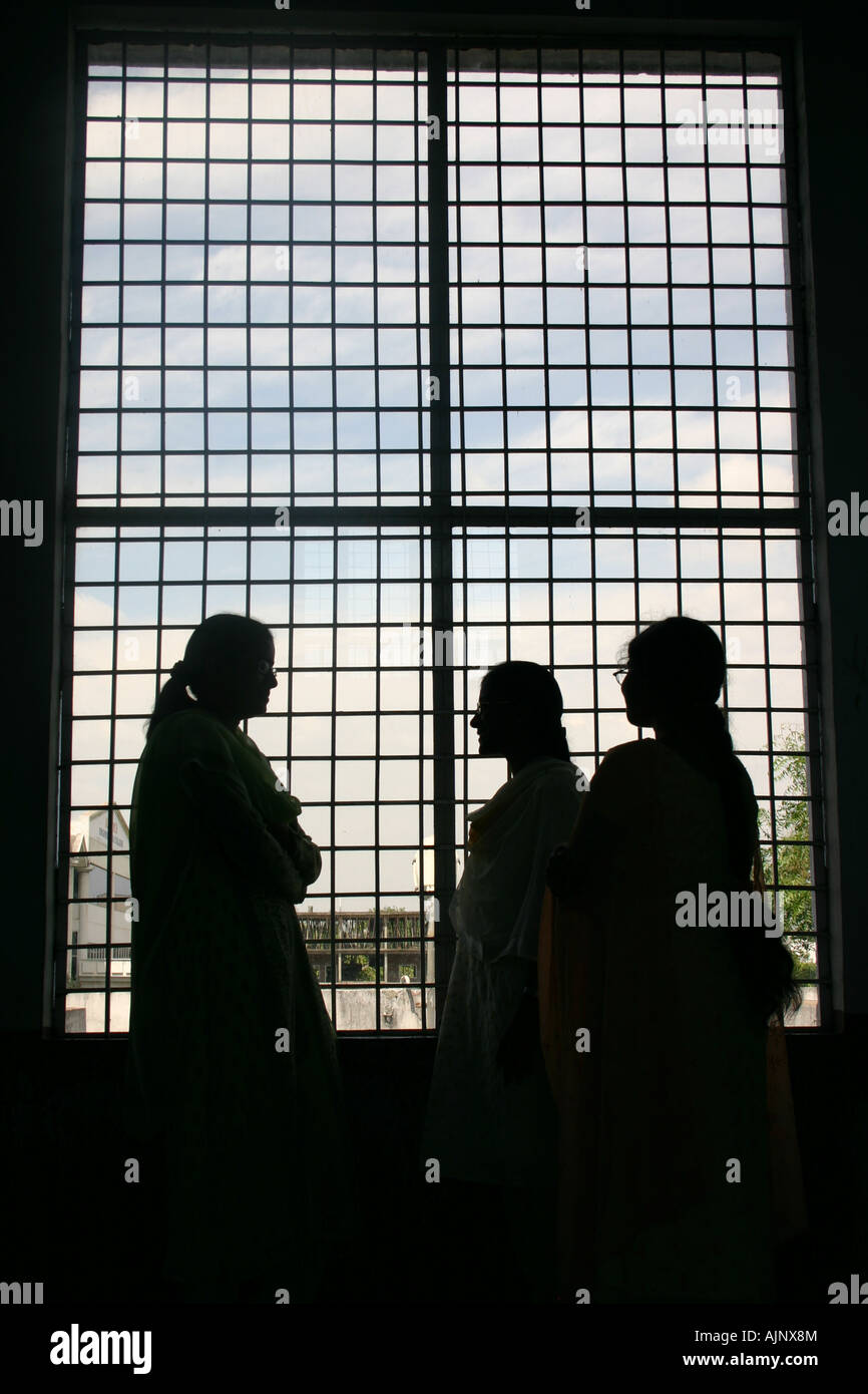 Silhouette of three woman standing by a window Stock Photo - Alamy