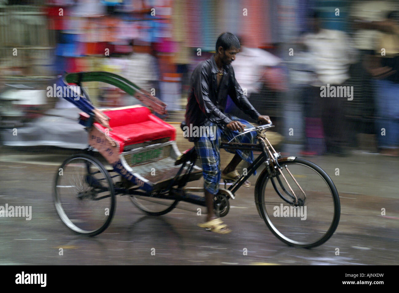 Rickshaw speeding rain street New Delhi cycling fast motion blur India ...