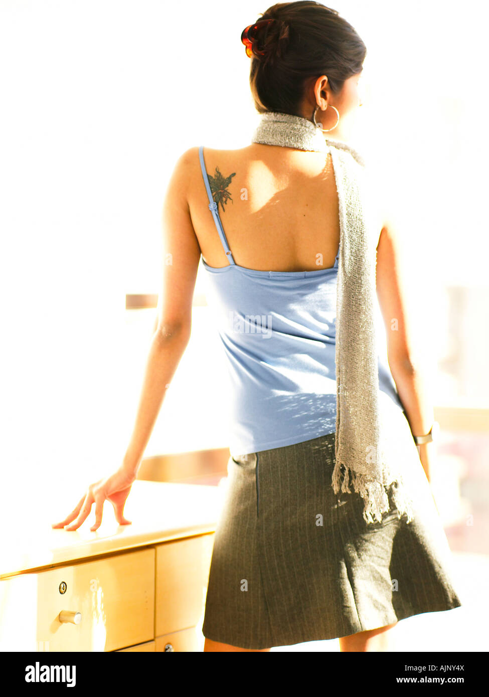 Rear view of a woman with a tattoo on her back Stock Photo - Alamy