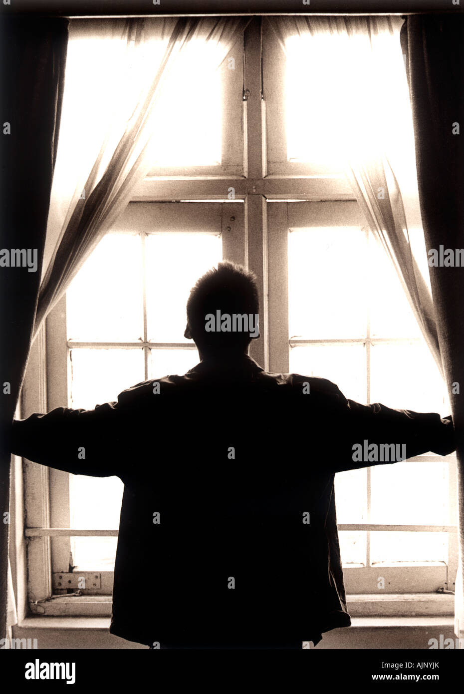 Boy against a window with light coming from the window Stock Photo - Alamy