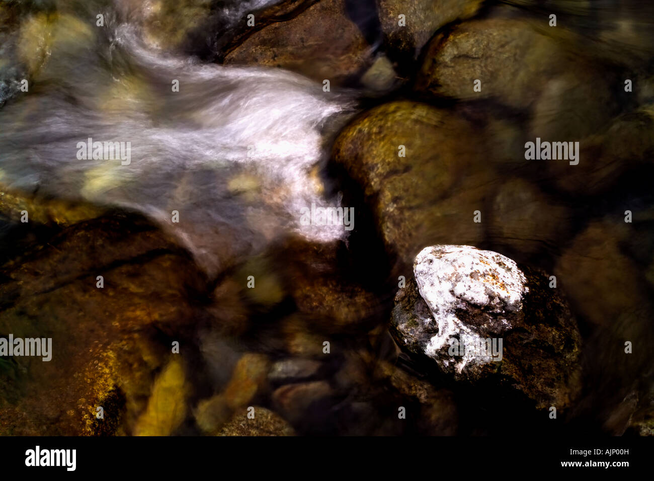 water flowing pass two stones on River Lowther, Lake District, Cumbria ...