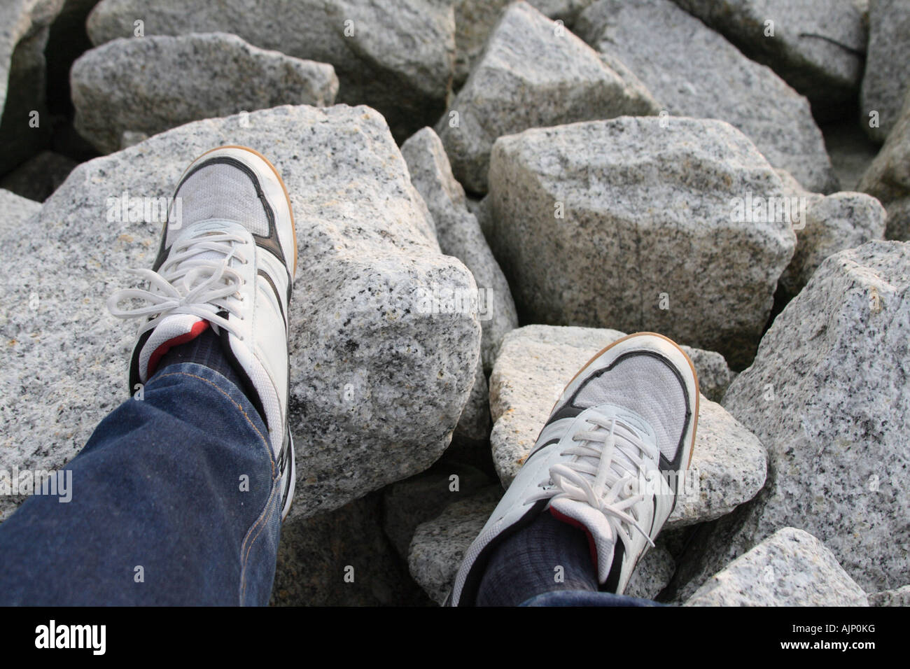 pair of feet stepping on rocks Stock Photo - Alamy