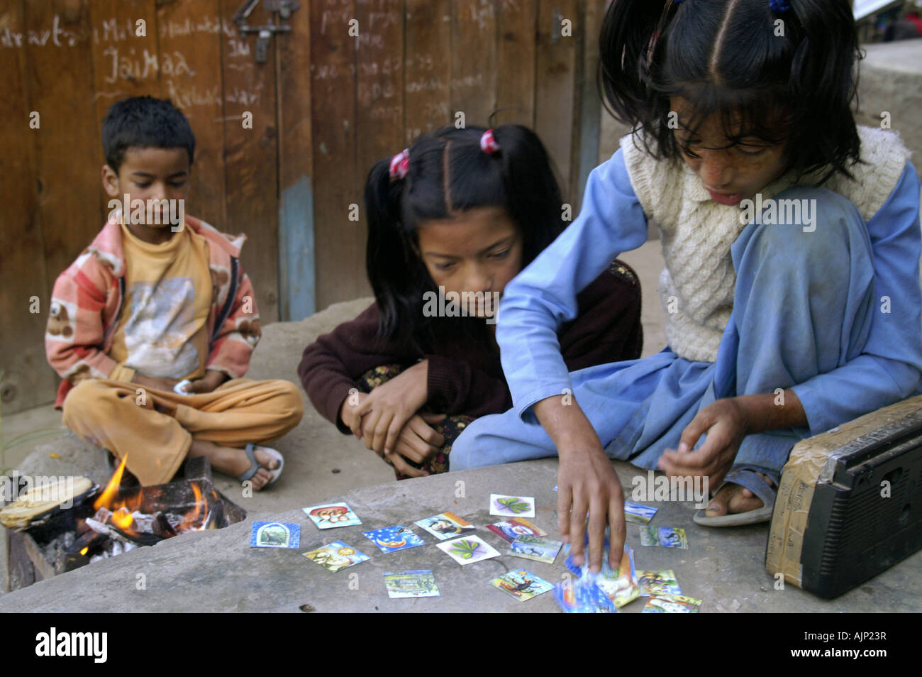 Three young indian girl boy kid playing card game thinking happy. India ...