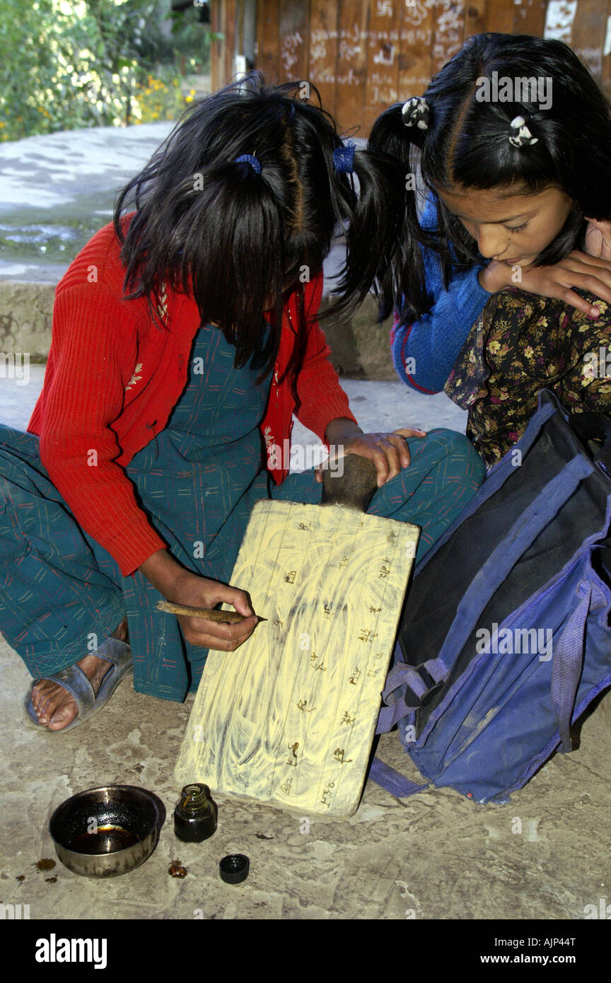 Two young indian girls writing homework outdoors Stock Photo - Alamy