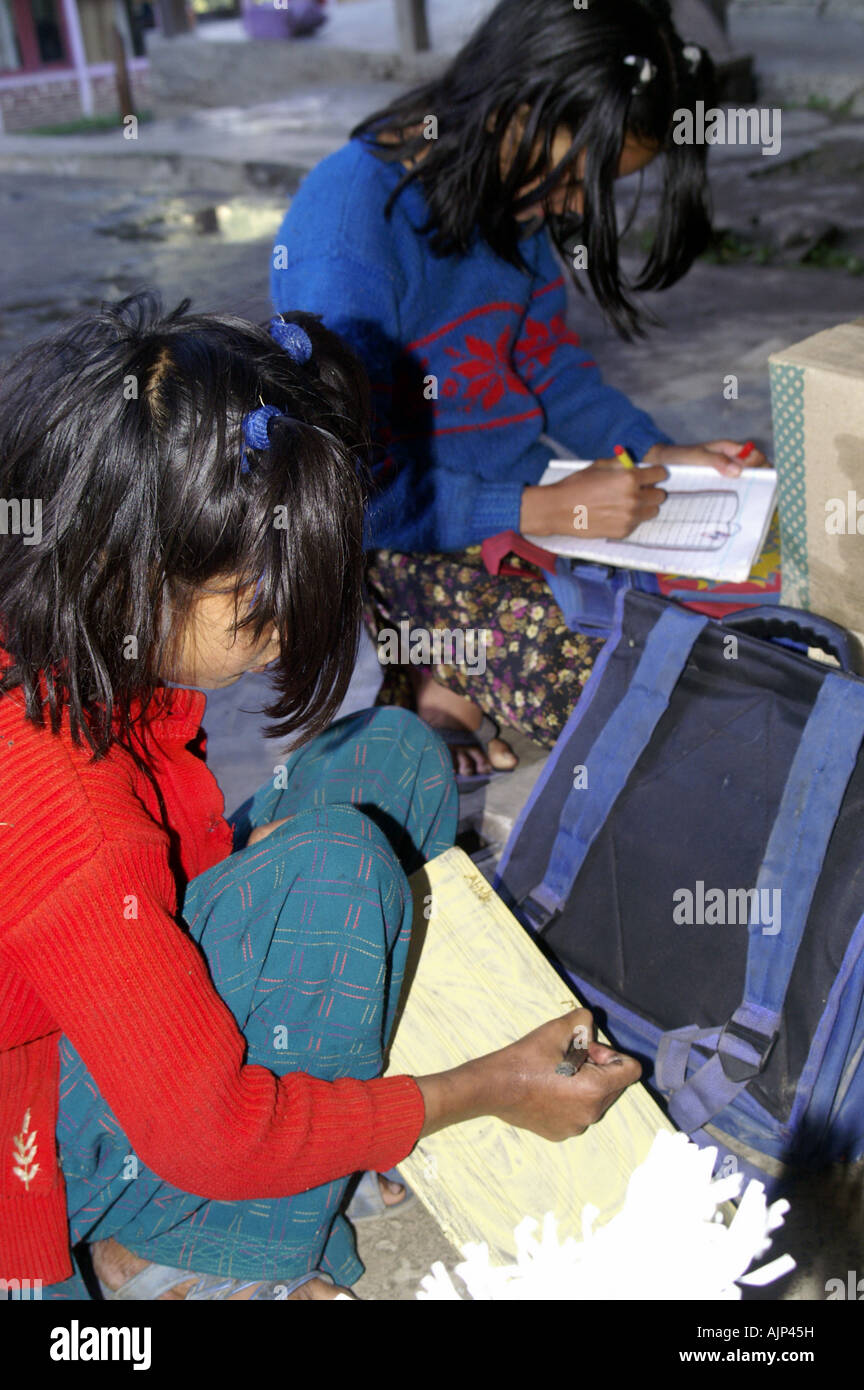 Two young indian girls writing homework outdoors Stock Photo - Alamy