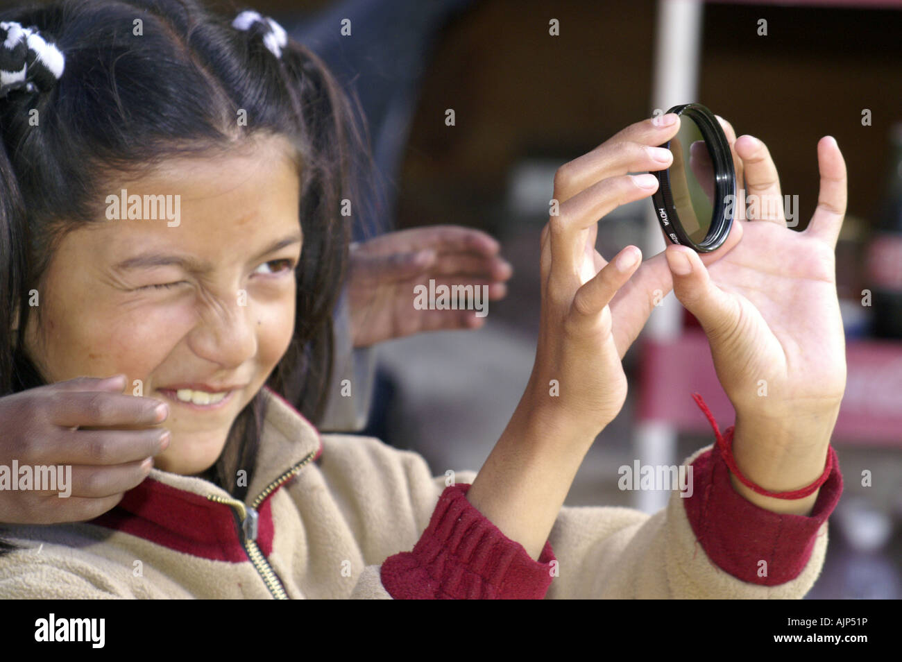 Indian girl child looking into polarizer filter, amazed. India Stock ...