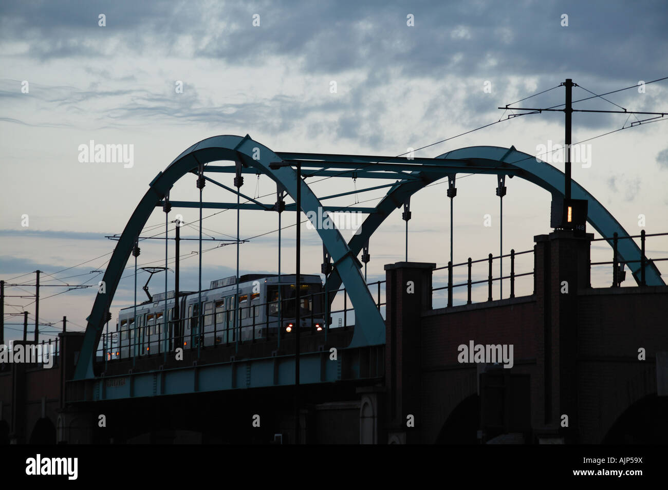 Tram crossing iron bridge in Manchester Stock Photo - Alamy