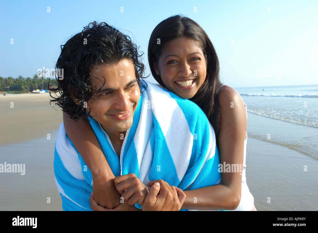 A young couple cuddling at a beach Stock Photo - Alamy