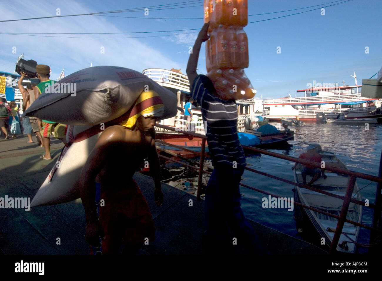 Dock workers transporting goods to and from boats at the main port ...