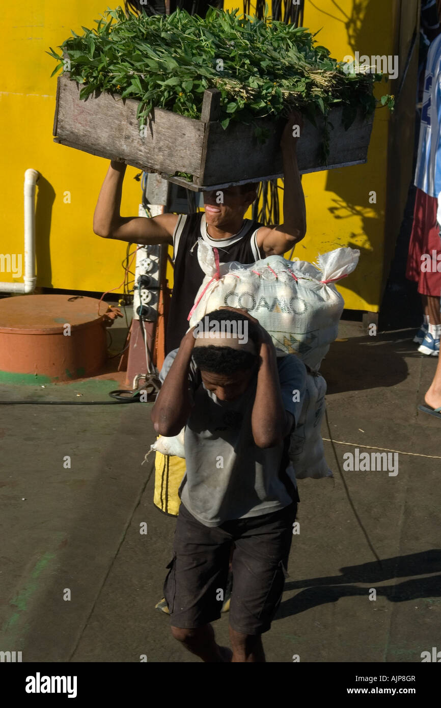 Dock workers transporting goods to and from boats at the main port ...