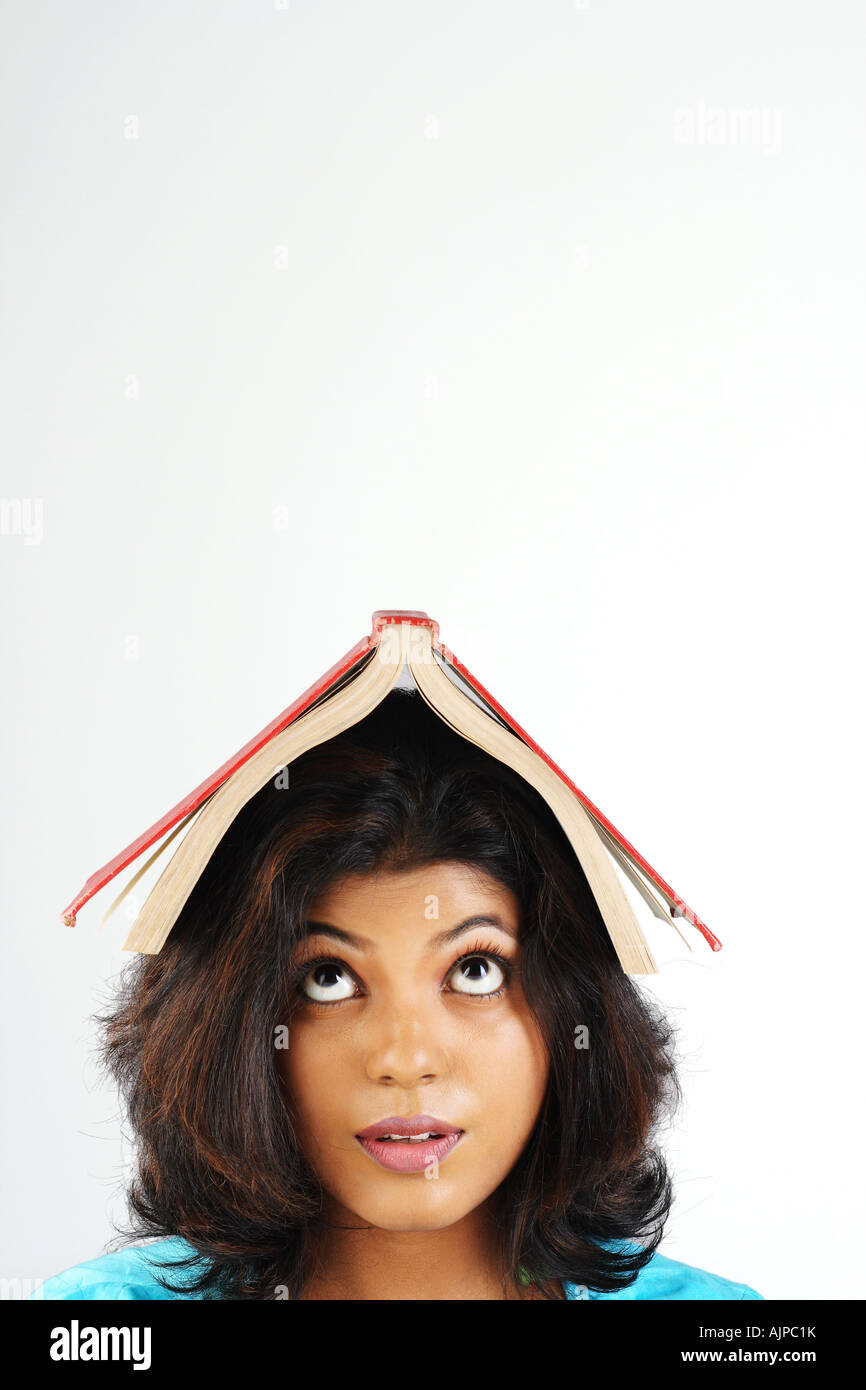 Portrait of a teenage girl with a book on her head Stock Photo - Alamy