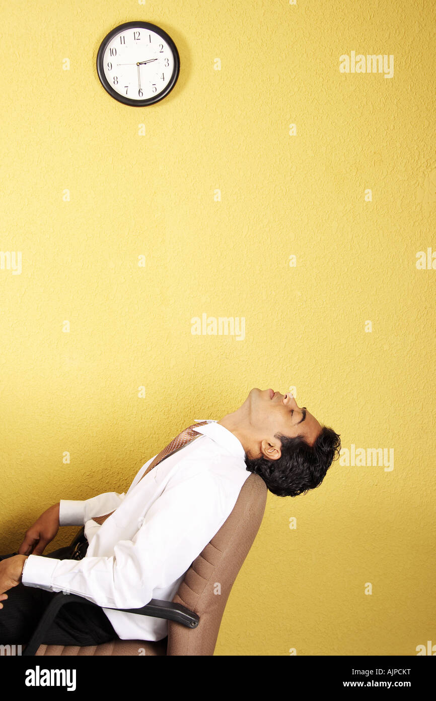 Businessman sleeping on a chair Stock Photo - Alamy