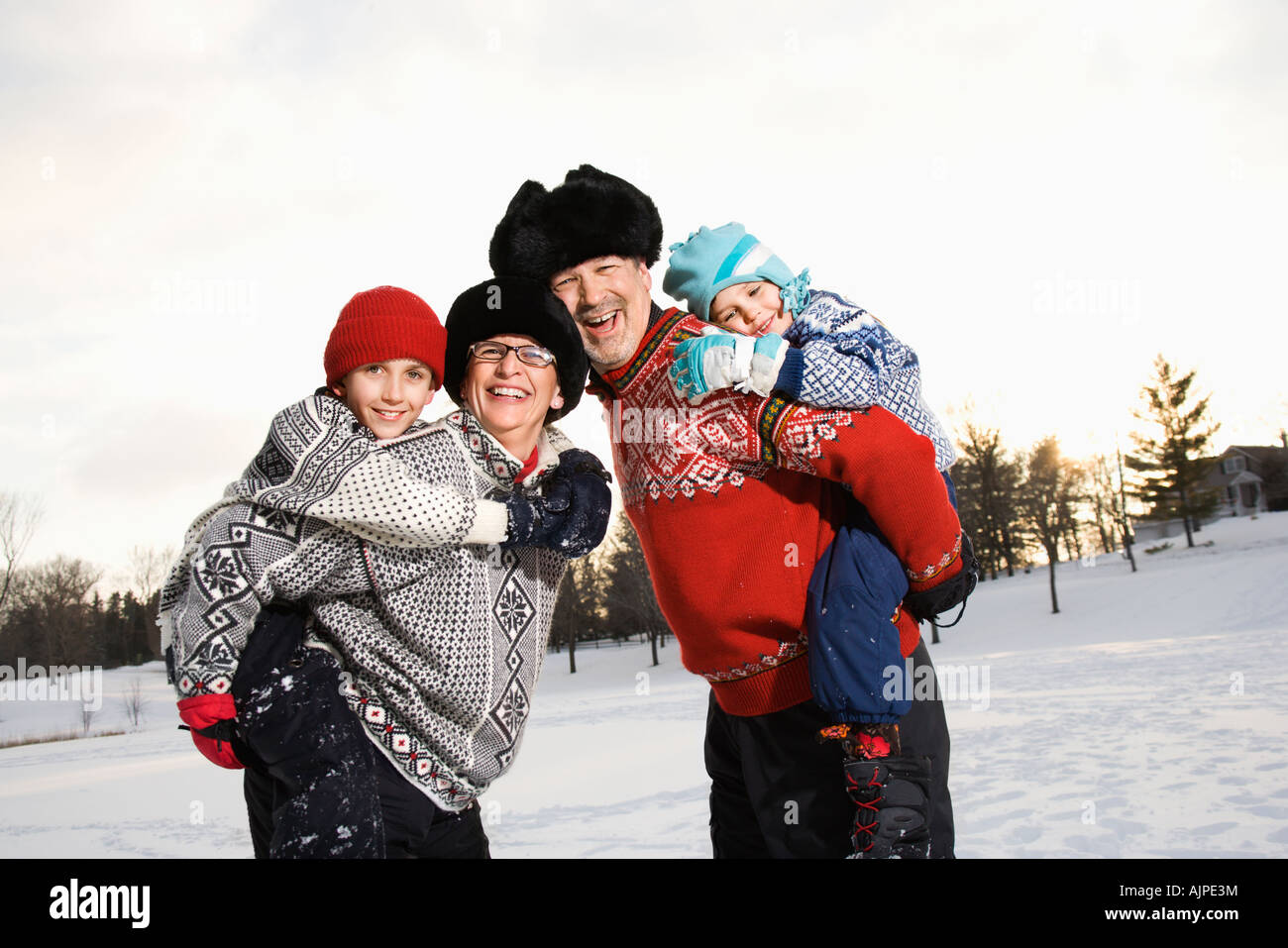 Caucasian middle aged parents carrying their Caucasian son and daughter ...