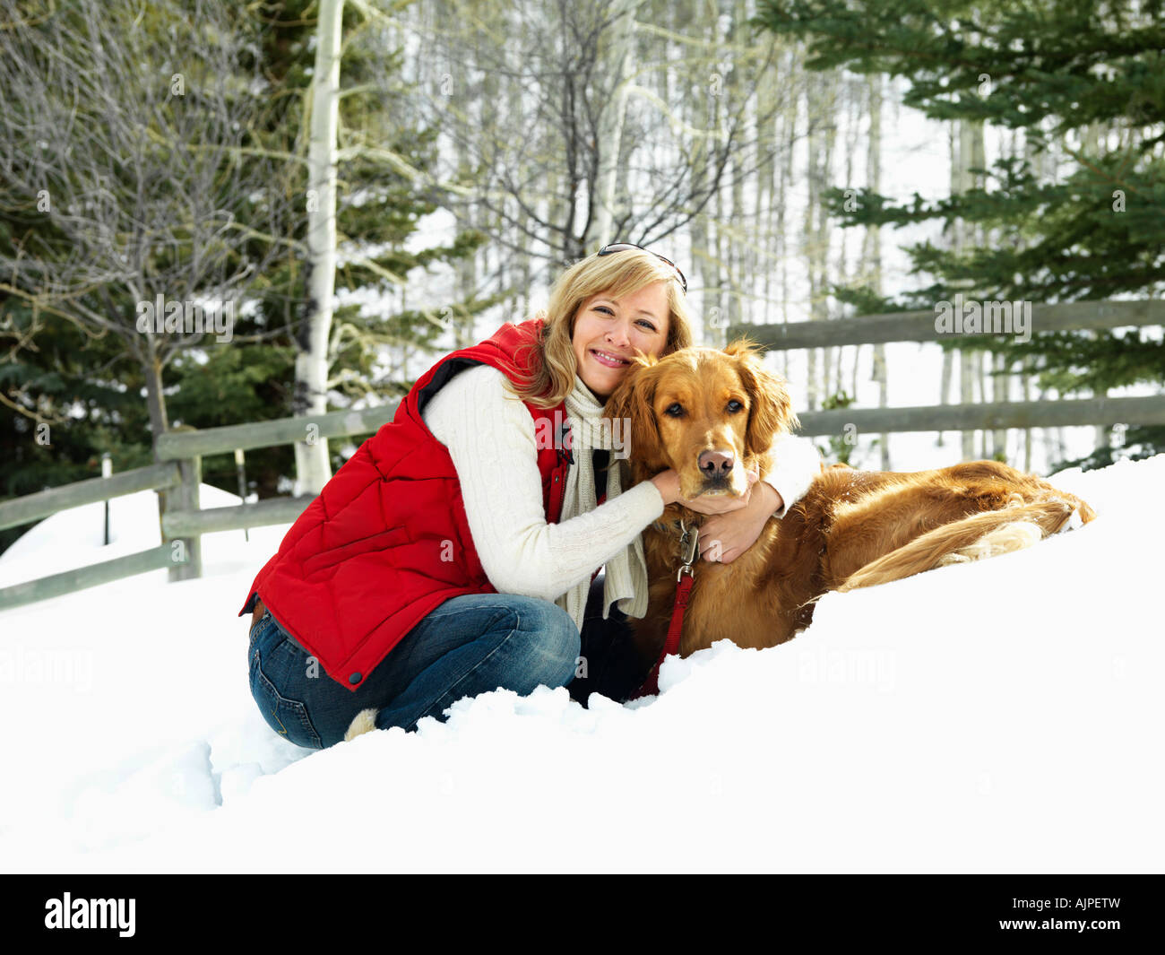 Woman hugging dog and smiling in snow covered Colorado landscape Stock ...