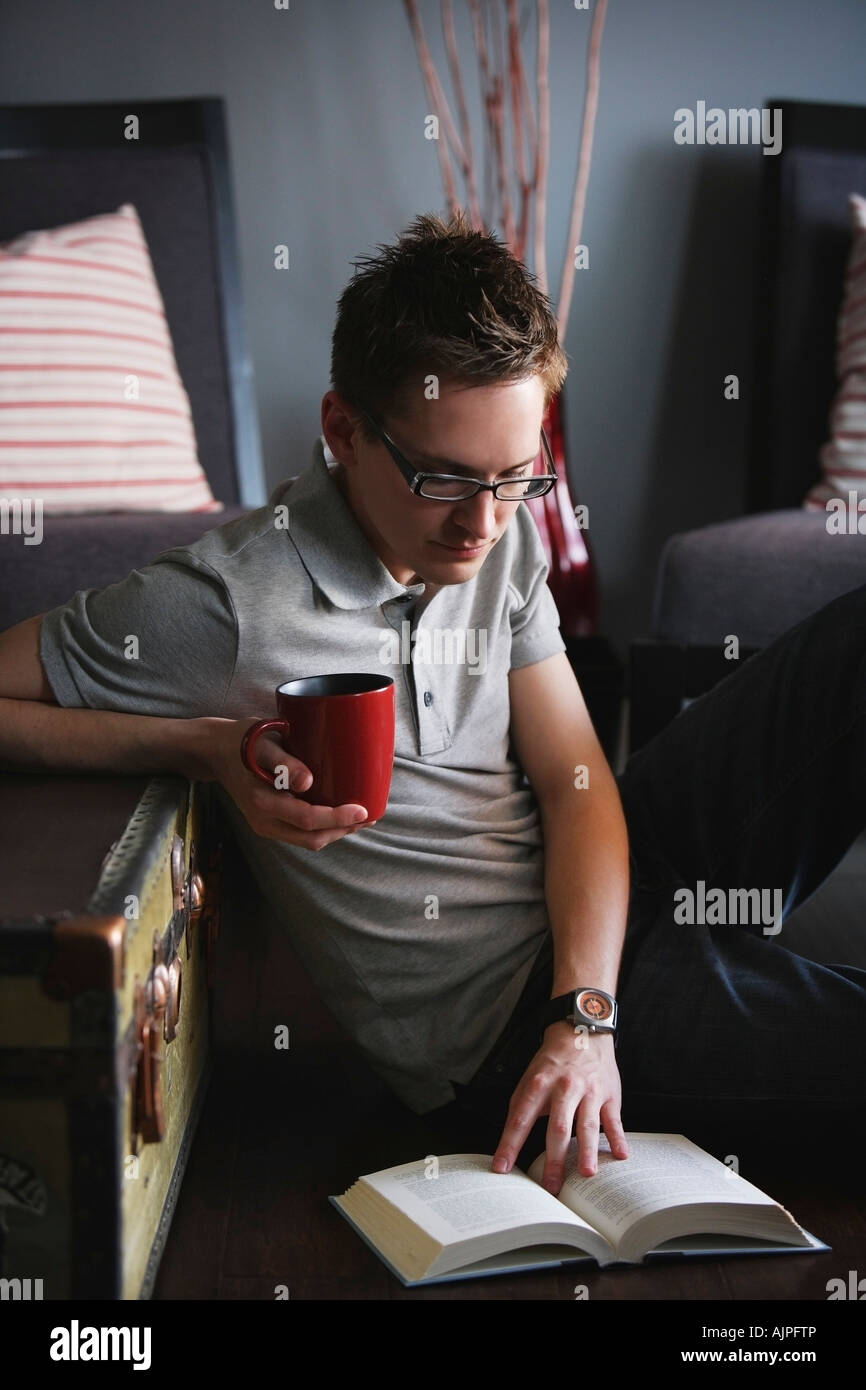 Man reading with hot drink Stock Photo - Alamy