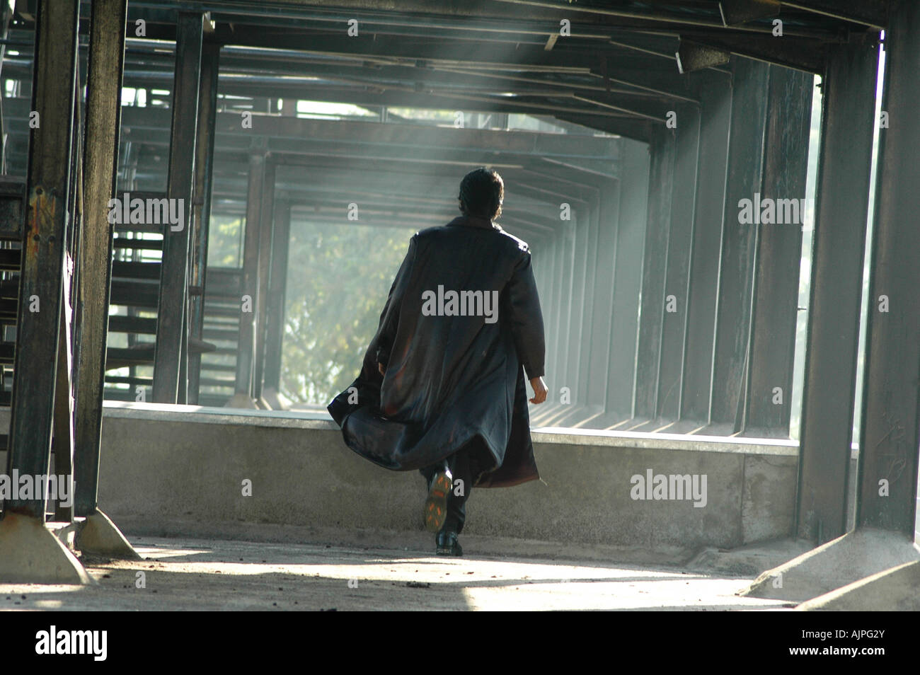 Rear view of a man walking in an isolated building Stock Photo - Alamy