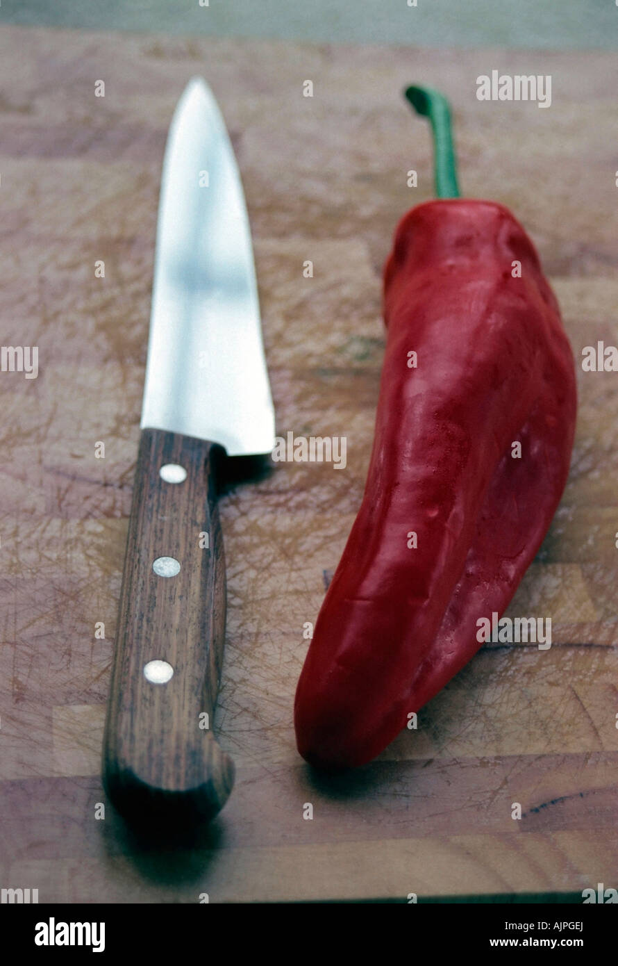 Knife and red pepper on chopping board Stock Photo - Alamy