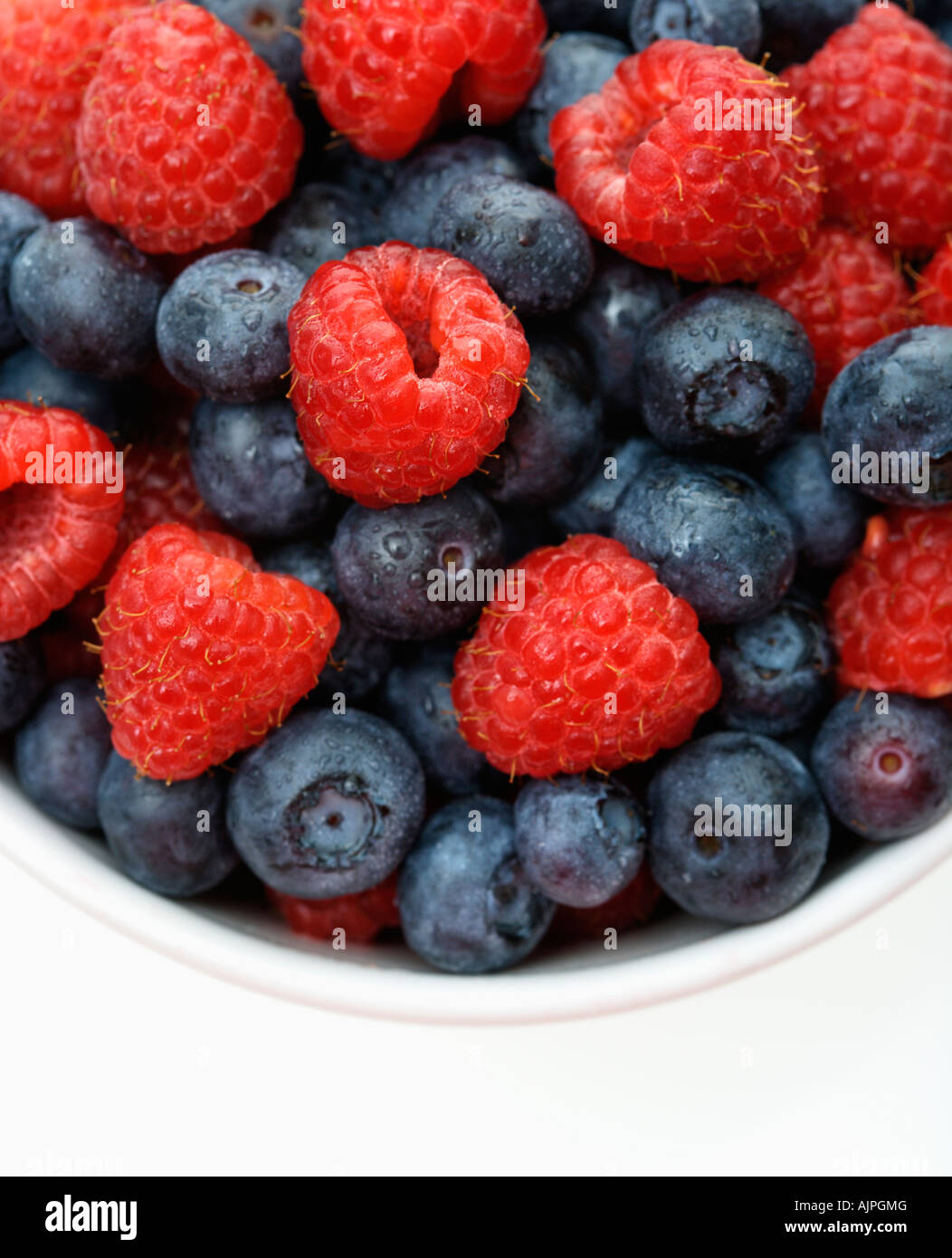 Bowl of mixed blueberries and raspberries on white background Stock ...