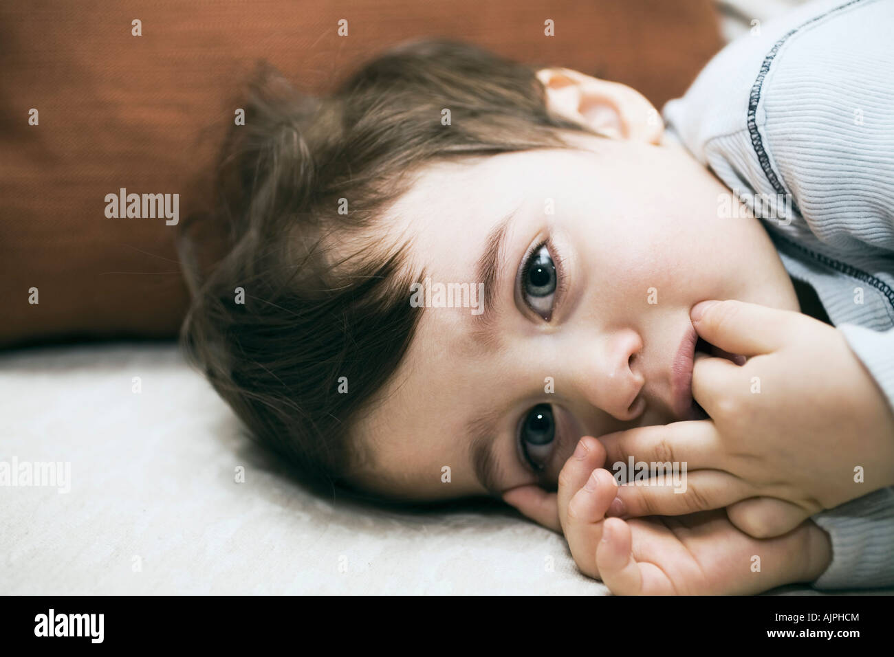 Sad toddler lying down Stock Photo - Alamy